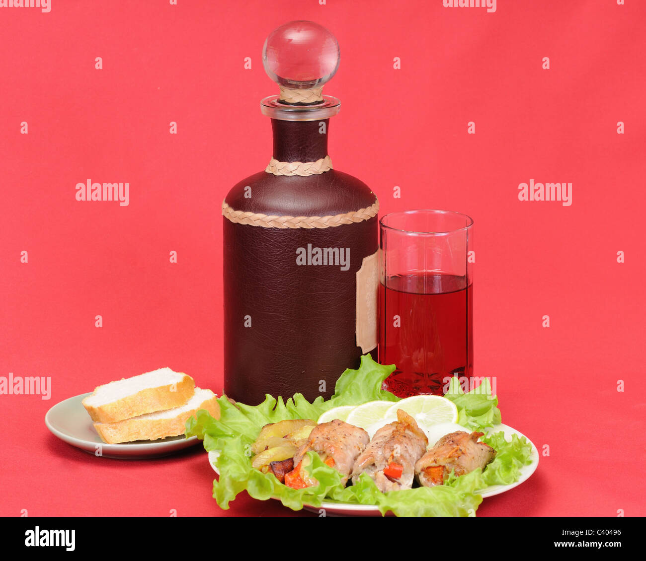 Still-life with meat and wine on a red background Stock Photo - Alamy
