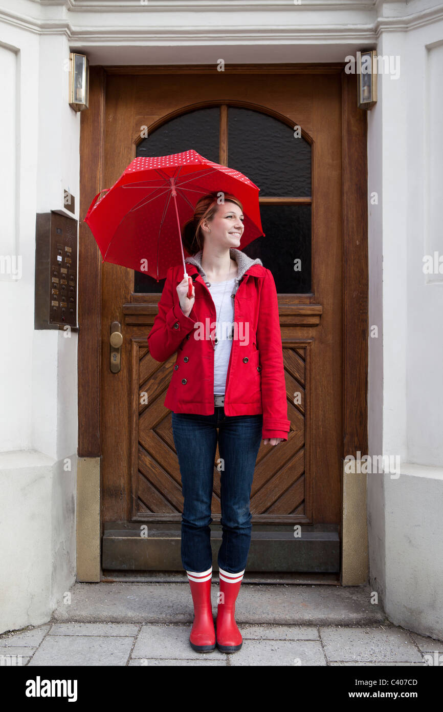 Woman with umbrella in front of house Stock Photo - Alamy