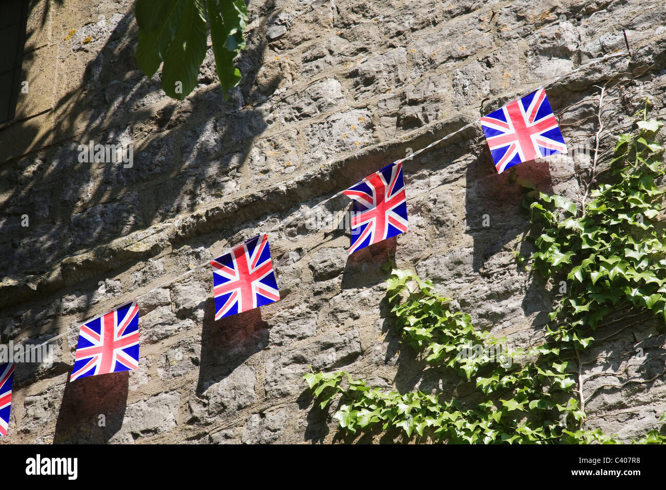 Union Jack flags hanging across an ancient wall Stock Photo - Alamy