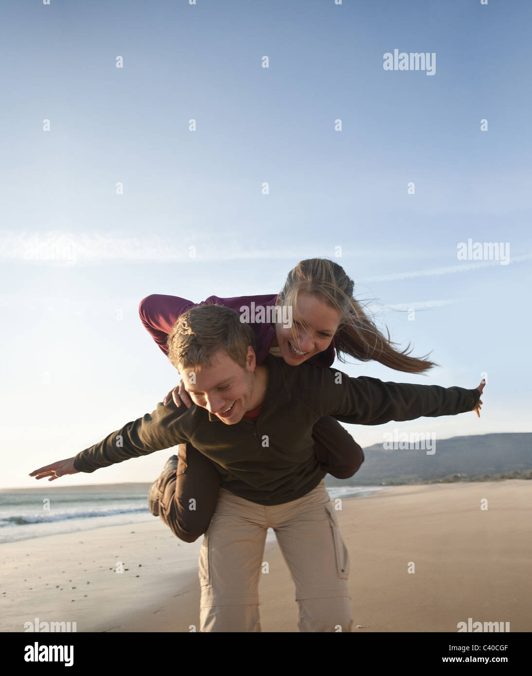 Young man giving woman piggyback ride Stock Photo - Alamy