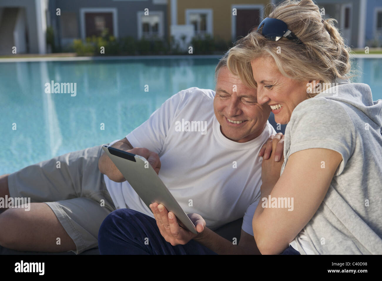 Woman reading tablet swimming pool hi-res stock photography and images ...