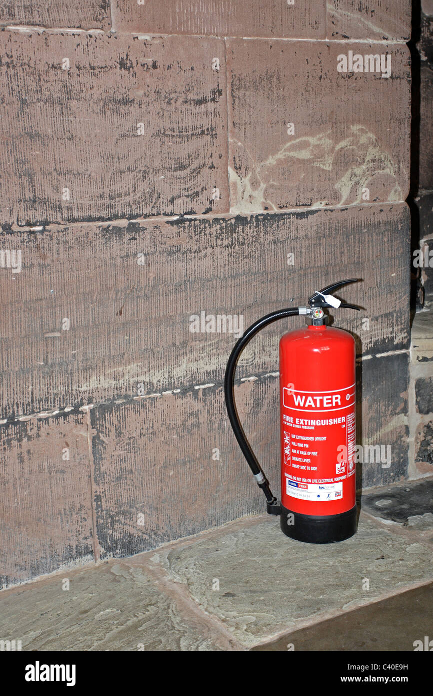 A water fire extinguisher against a stone wall Stock Photo - Alamy