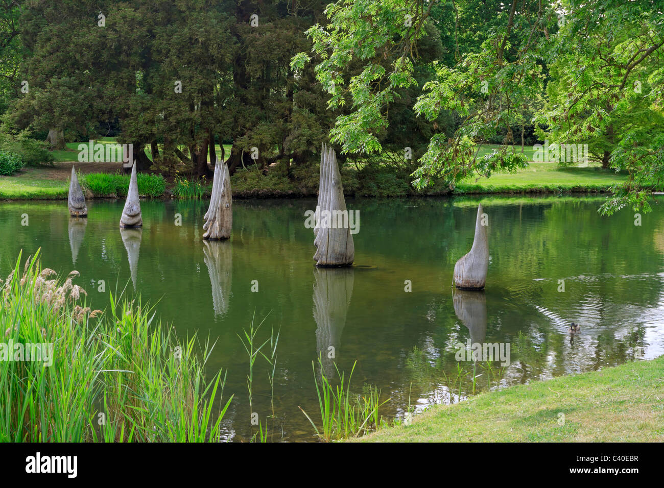 Modern sculpture of five wood carvings in the lake in the landscape ...