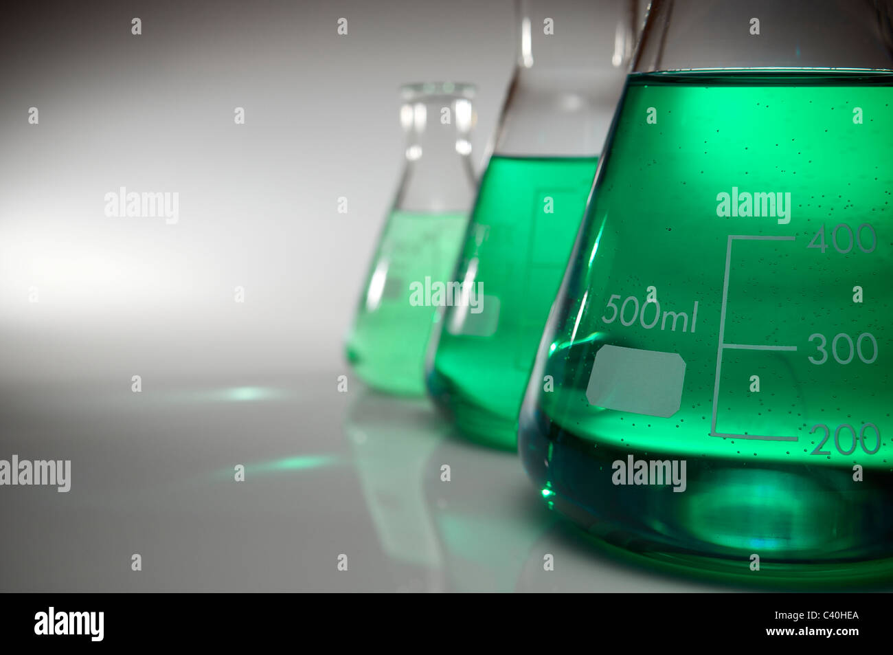 detail of three flasks containing green liquid Stock Photo - Alamy