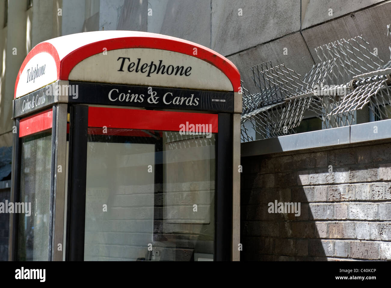 London , Kings Cross , public telephone box kiosk coin & card by brick ...