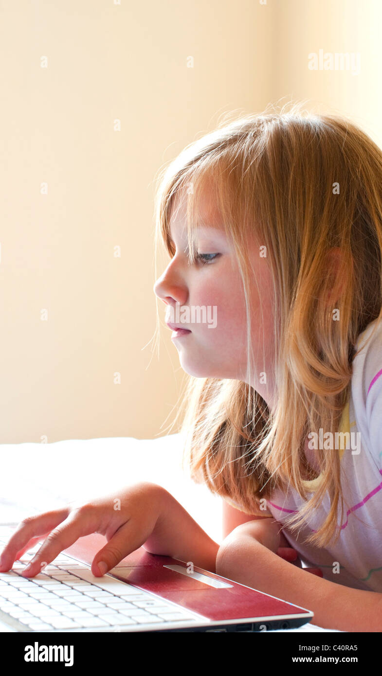 Young girl typing on laptop Stock Photo - Alamy