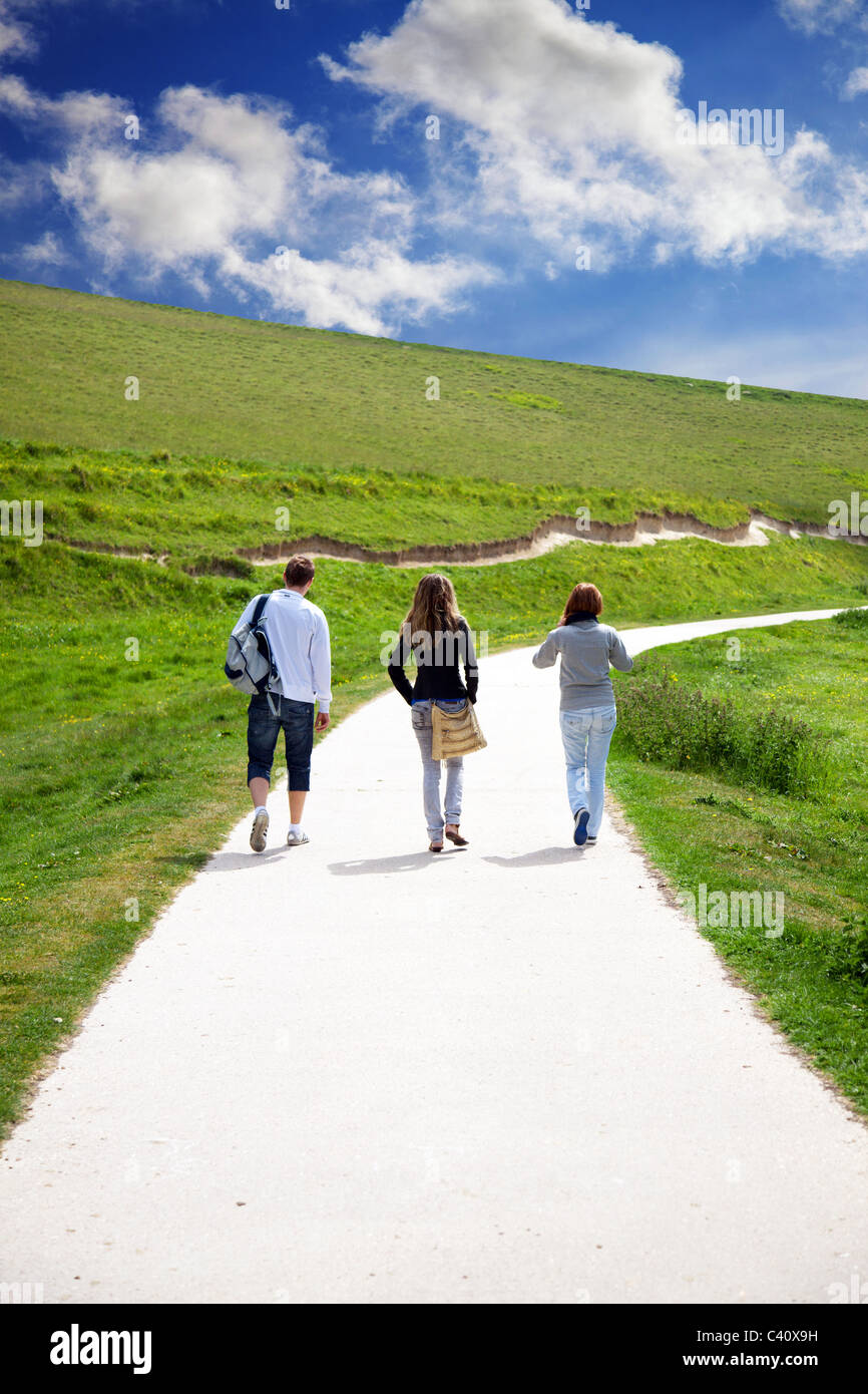 Three friends walking down a footpath in beautiful scenery Stock Photo ...