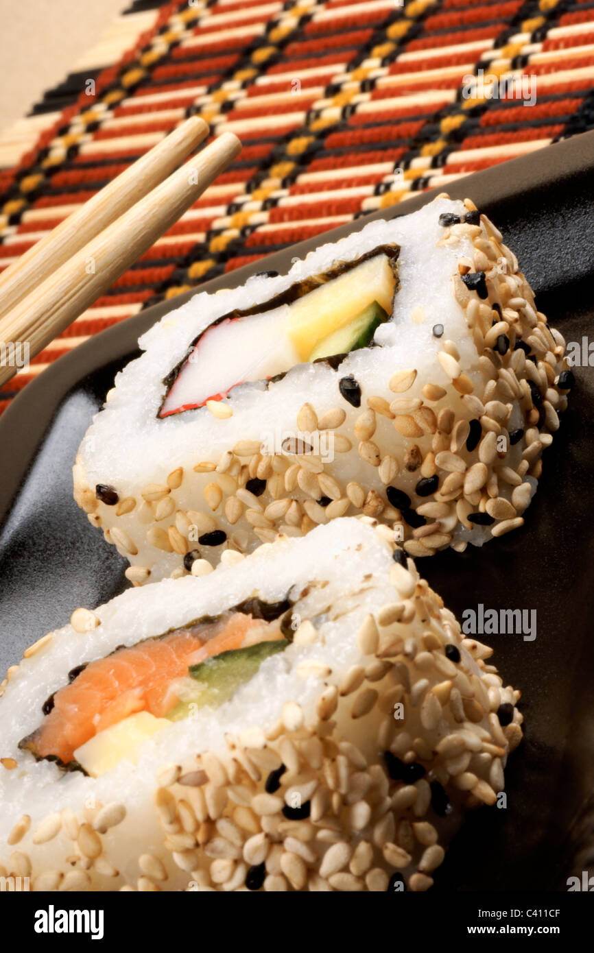 Assorted japanese maki sushi on a black tray with chopsticks, ready to ...