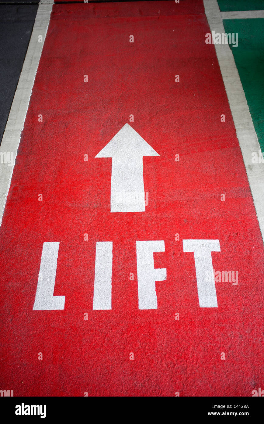 arrow and sign for lift on a red walkway Stock Photo - Alamy