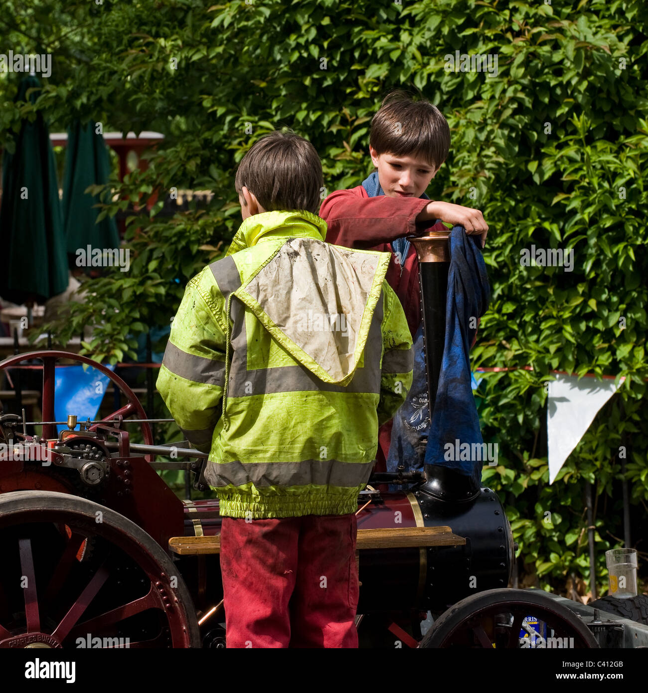 Two young boys working on a miniature steam traction engine Stock Photo ...