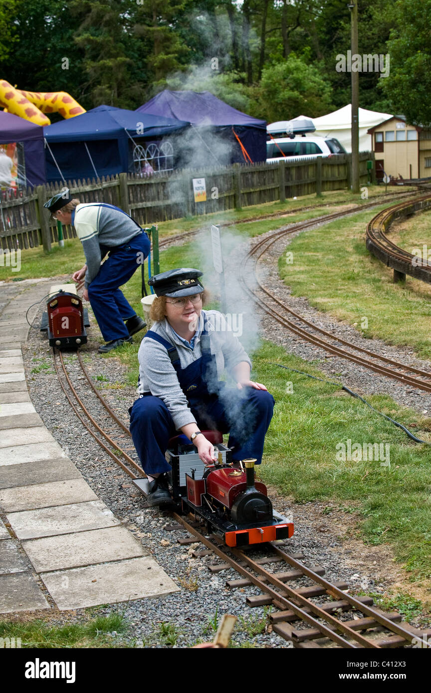 A female sitting on a miniature steam railway engine Stock Photo - Alamy