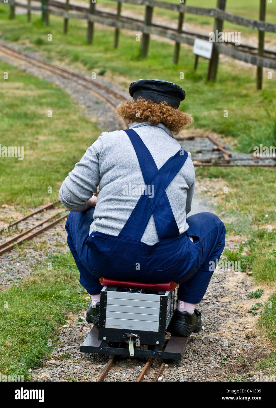 A female sitting on a miniature steam railway engine Stock Photo - Alamy