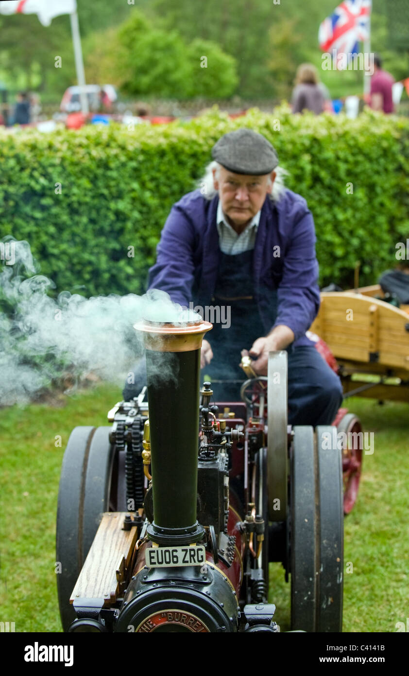 A man driving a miniature steam traction engine at a steam fair Stock ...