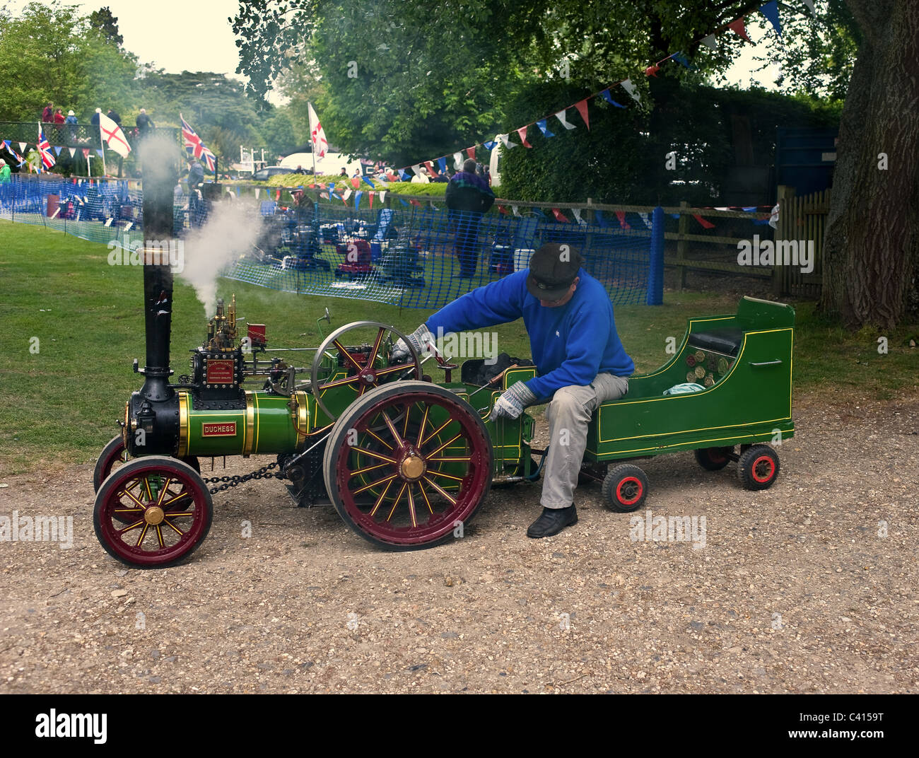 A man sitting on a miniature steam traction engine at a steam rally ...