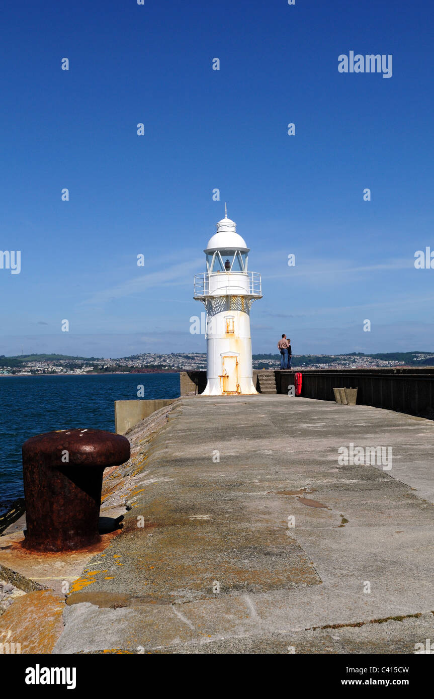Couple standing by Brixham Lighthouse looking at the sea Devon England ...