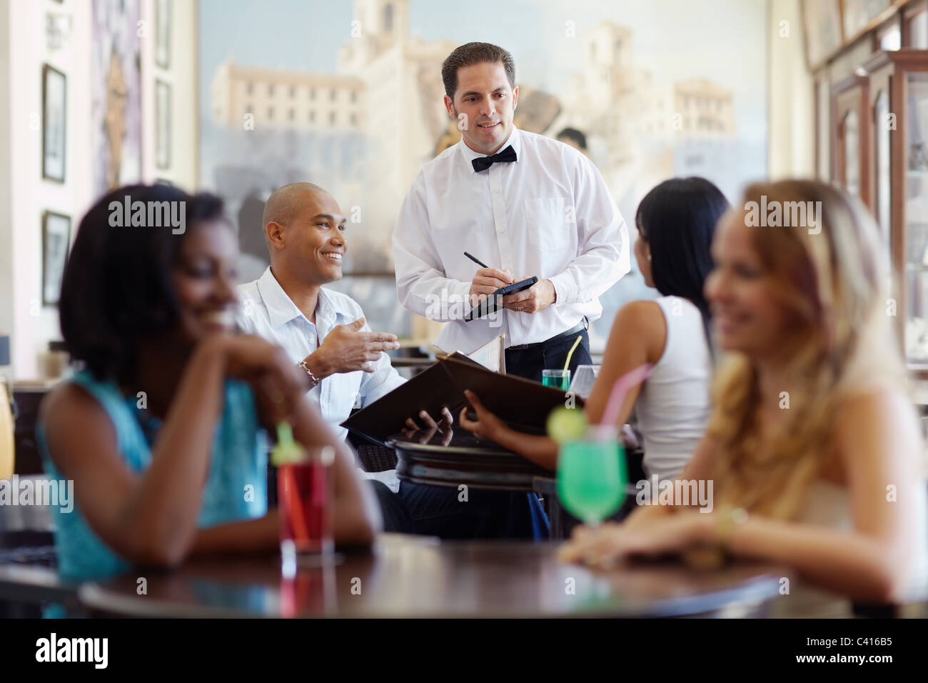 young adult hispanic couple dining out in restaurant and talking to ...