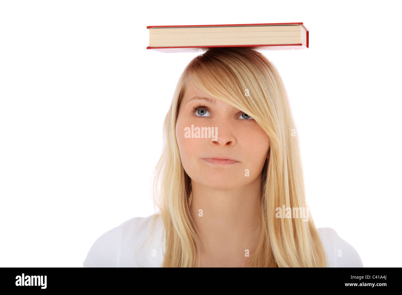 Attractive teenage girl balancing a book on her head. All on white ...