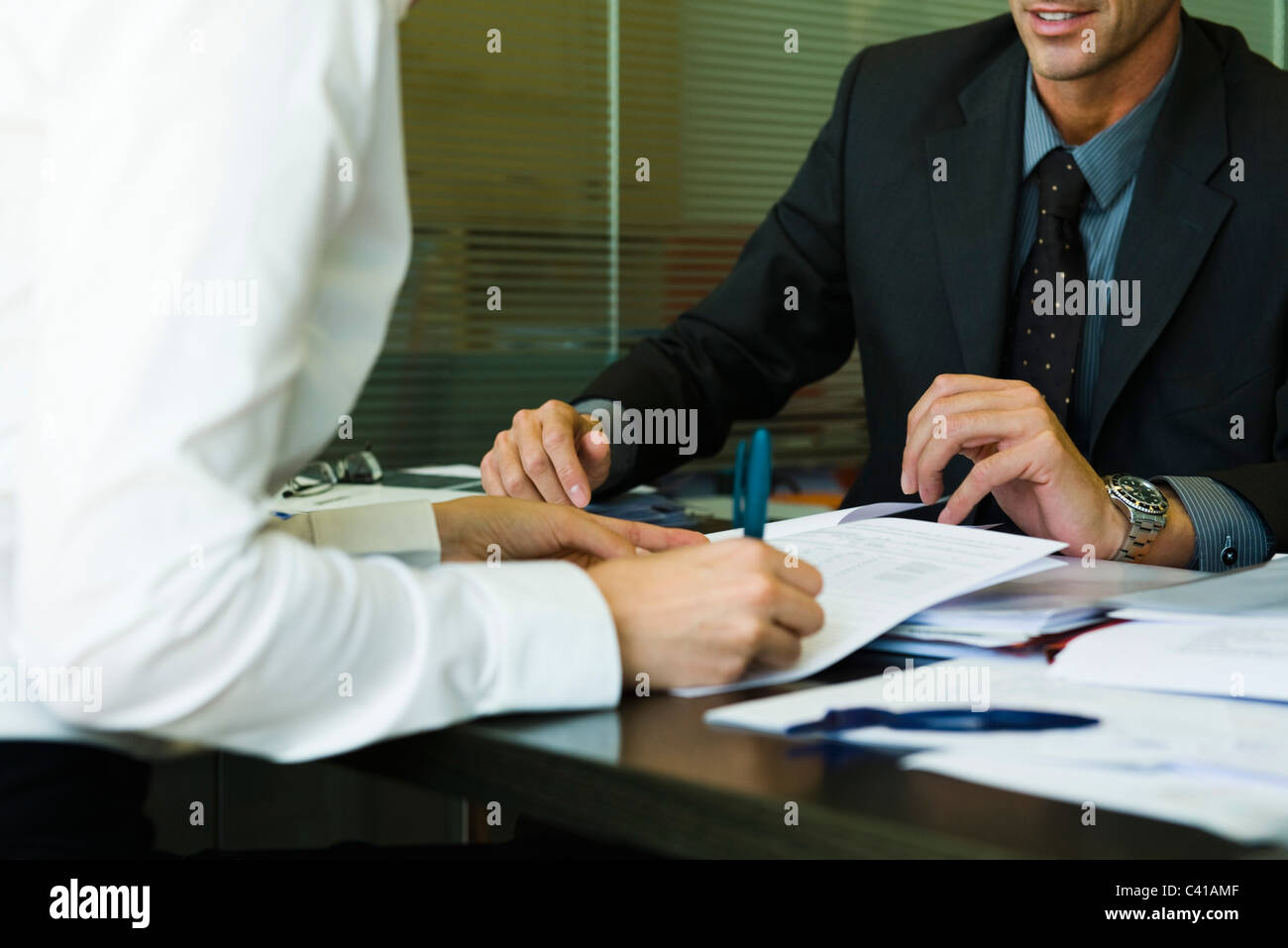 Person signing document in meeting with executive Stock Photo - Alamy