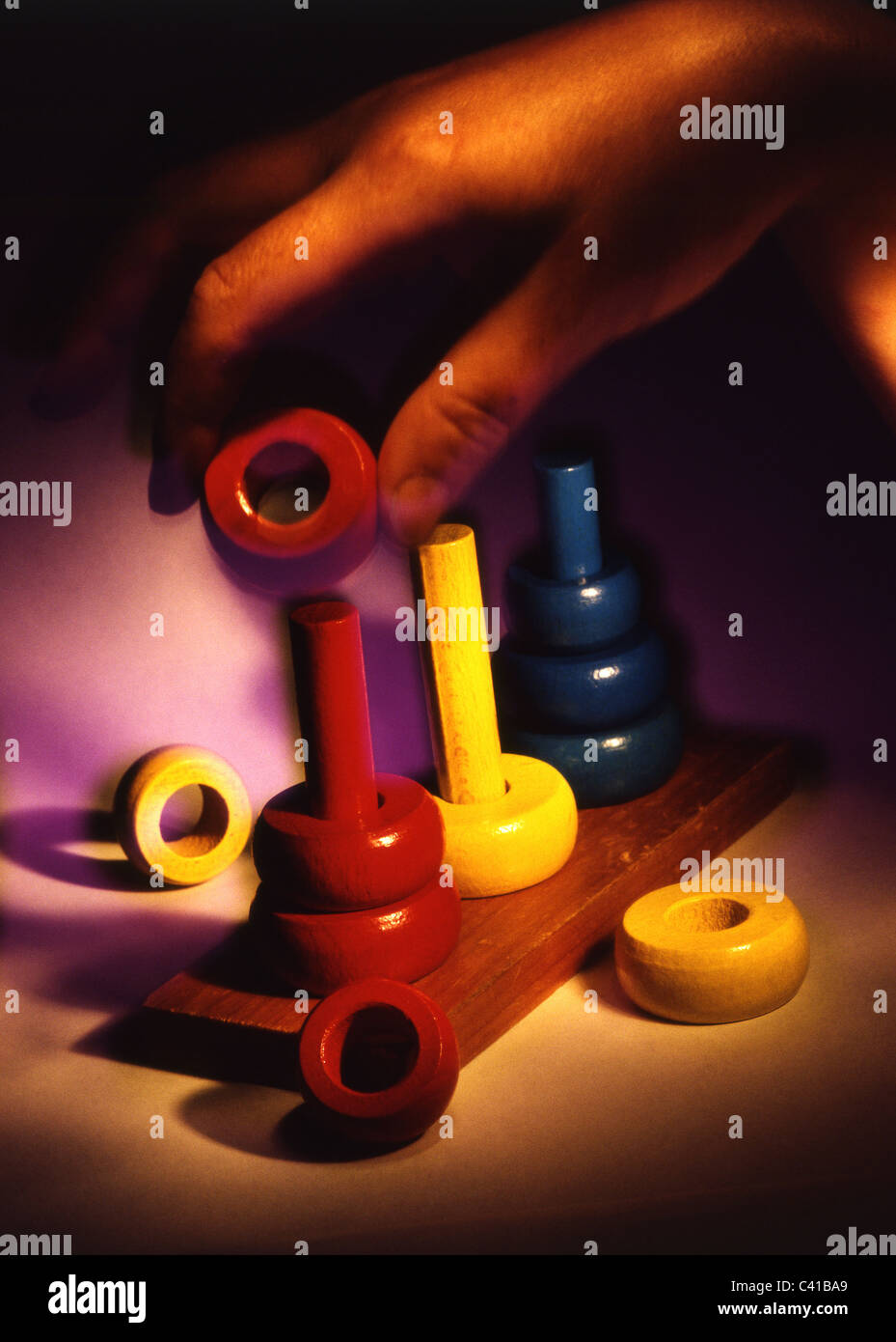 Hand placing a coloured ring on a children's counting toy Stock Photo ...