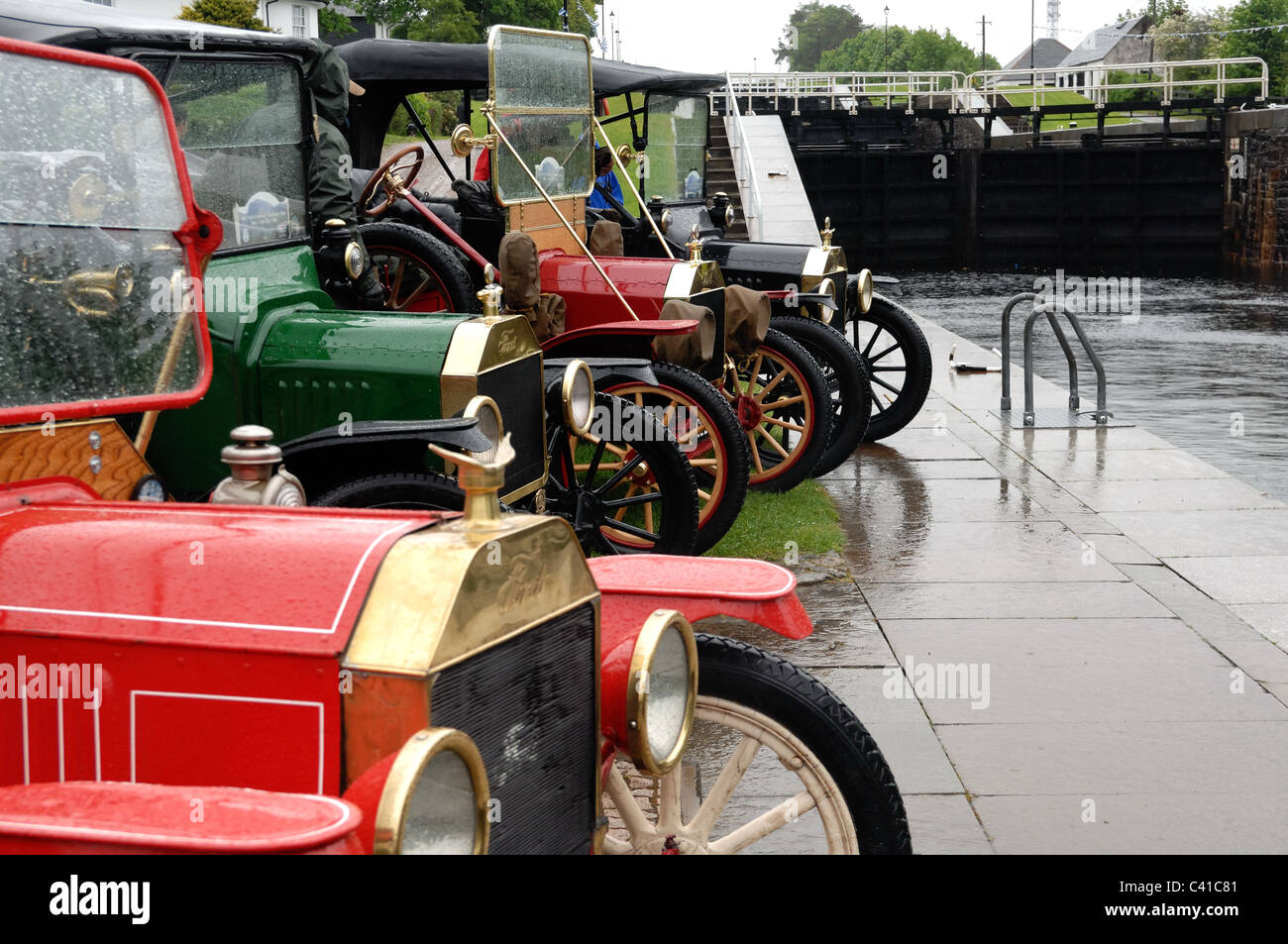 A line of model T Fords sitting on the Caledonian canal for photo shoot ...