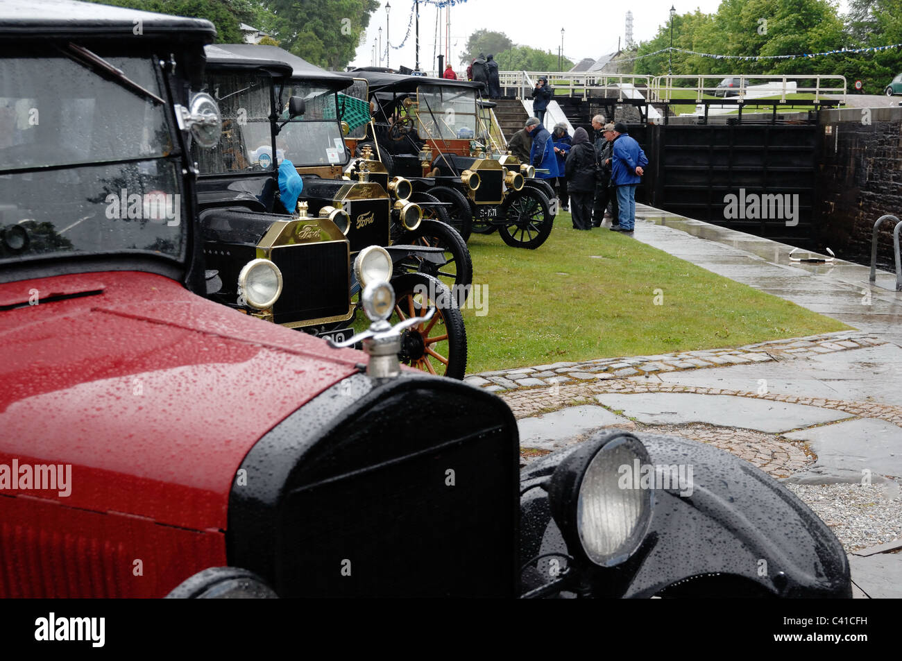 A line of model T Fords sitting on the Caledonian canal for photo shoot ...