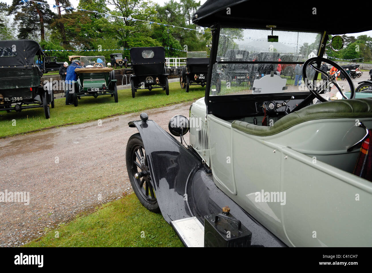 A line of model T Fords sitting on the Caledonian canal for photo shoot ...