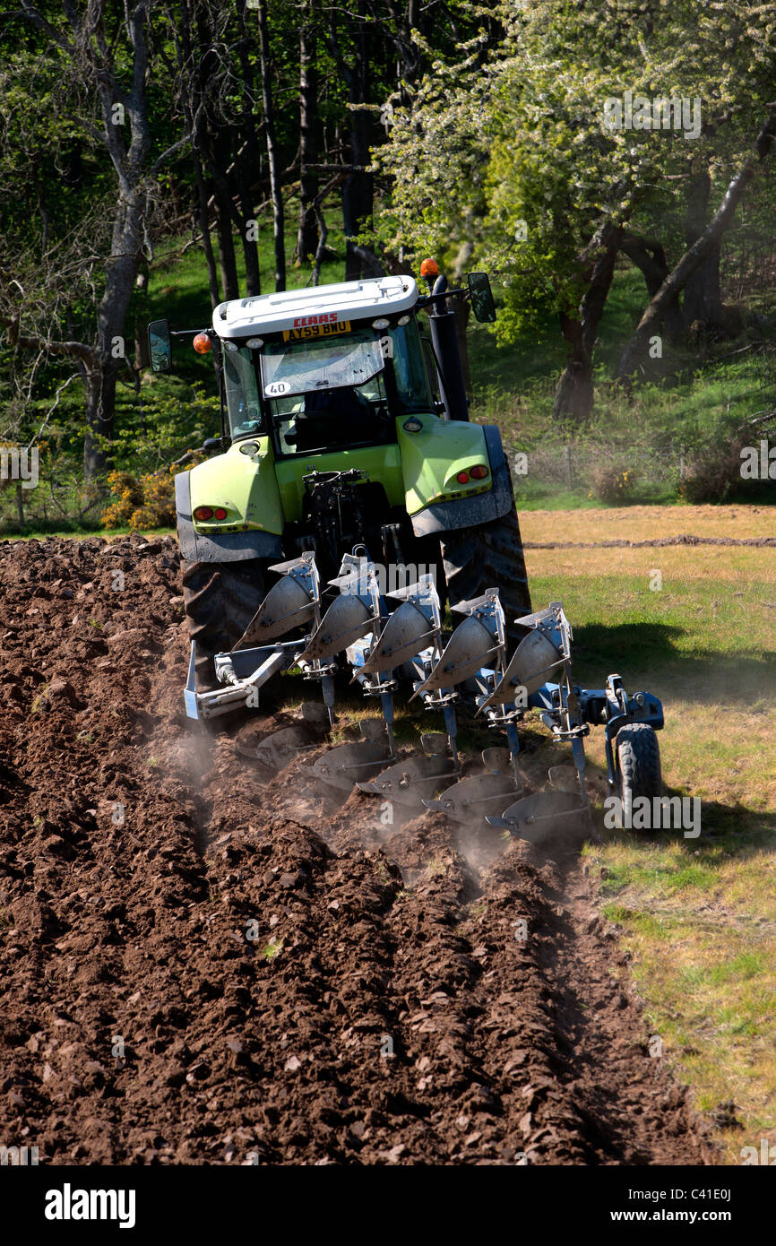 Colourful tractors ploughing fields in Spring time. Aberdeenshire ...