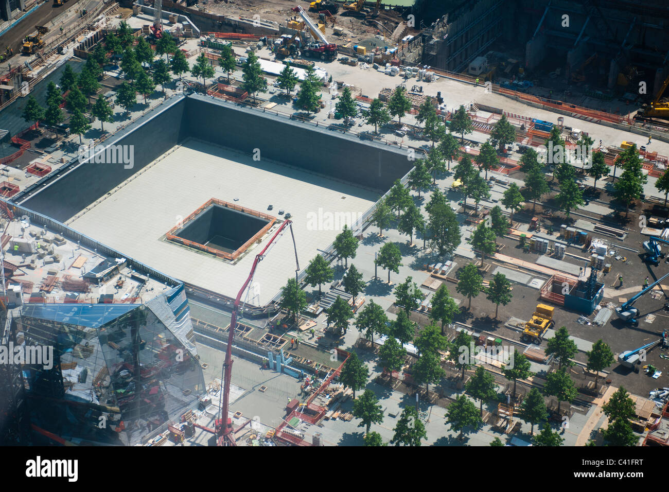 The under construction 9/11 Memorial and Museum with their reflecting ...