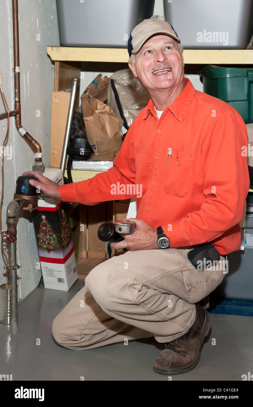 A technician checks the water meter during a Green Blocks energy audit ...