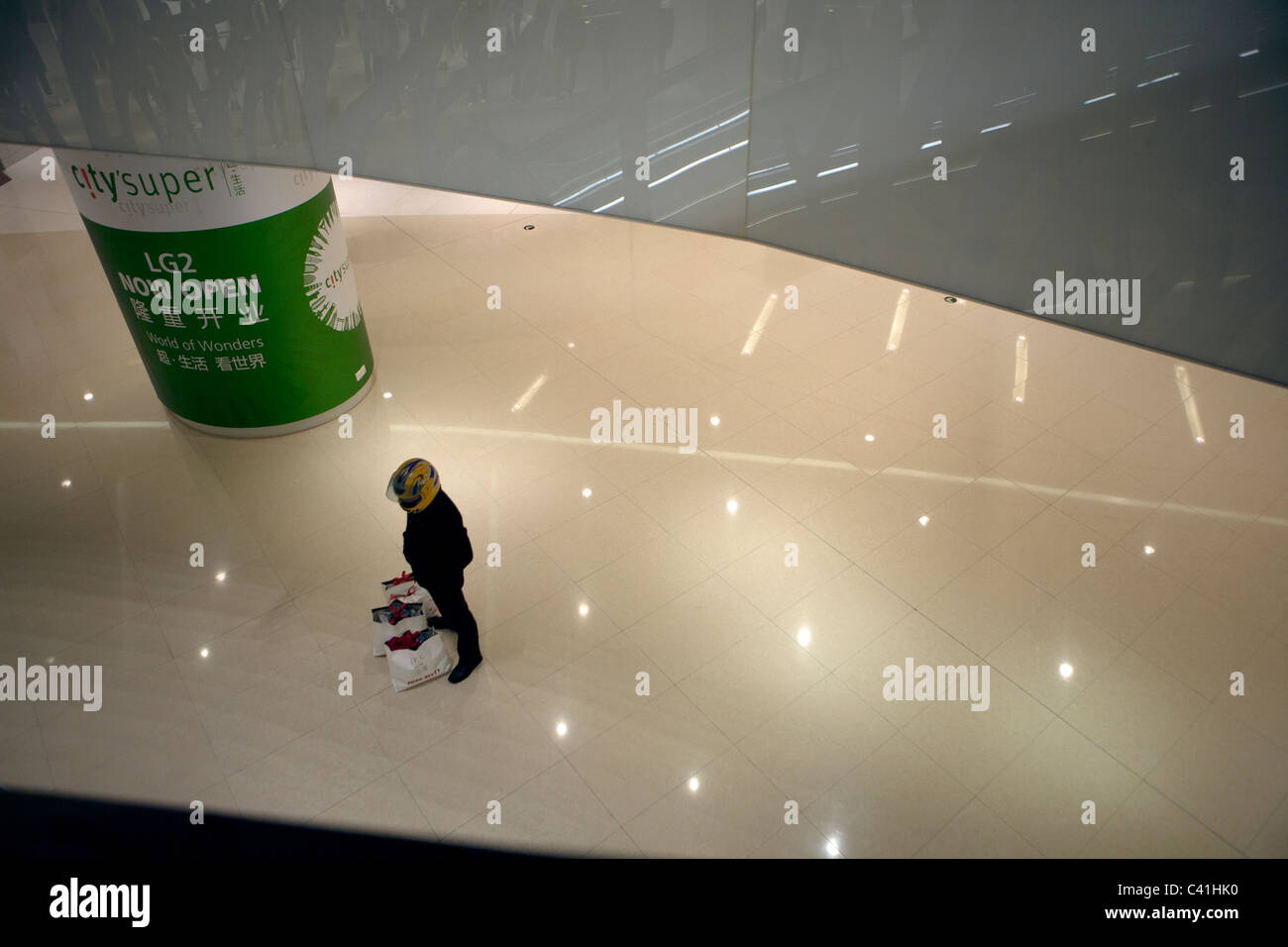 Man standing with shopping bags in parking lot of mall, Pudong ...