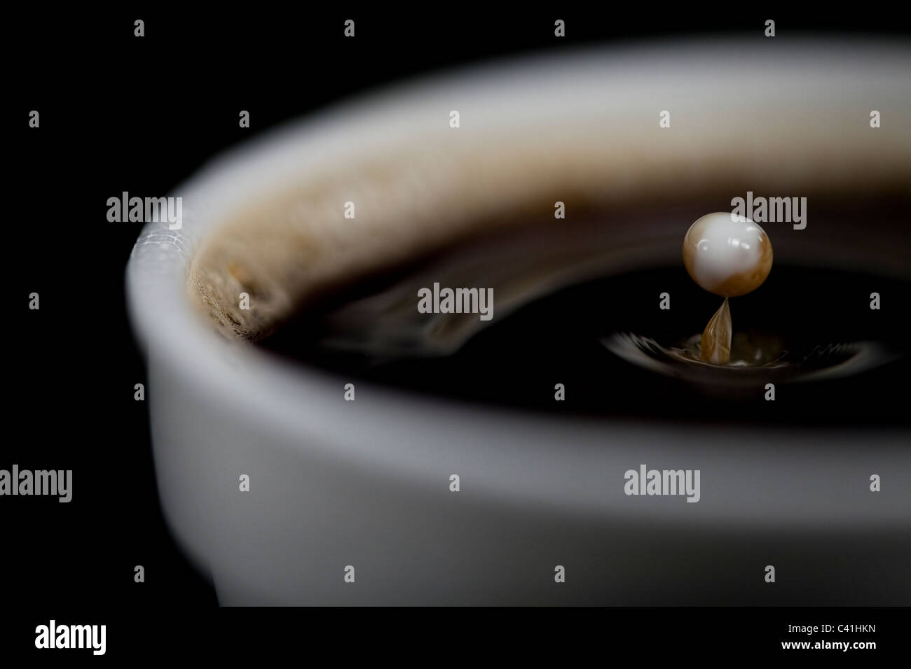 Milk drop in cup of coffee Stock Photo - Alamy