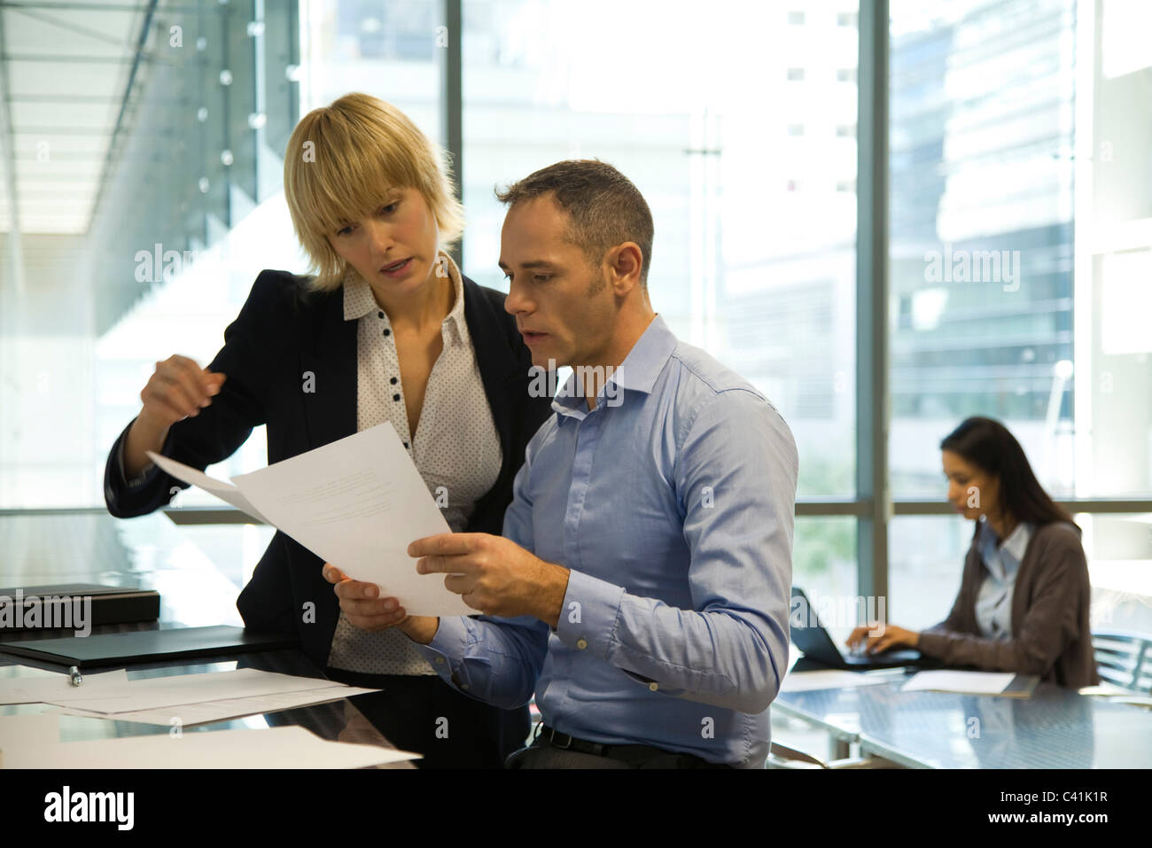 Colleagues discussing document Stock Photo - Alamy
