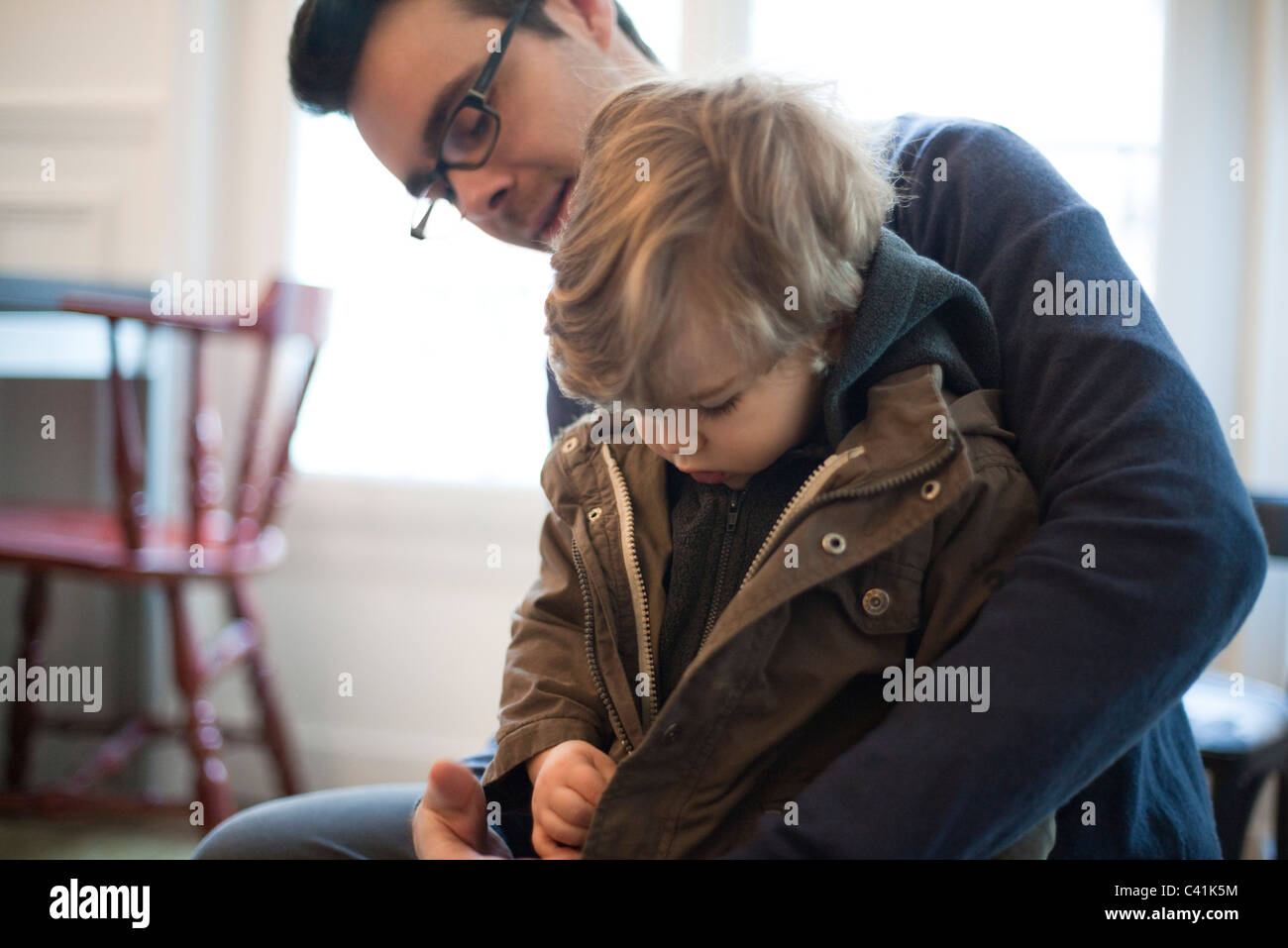 Father helping toddler son zip jacket Stock Photo - Alamy