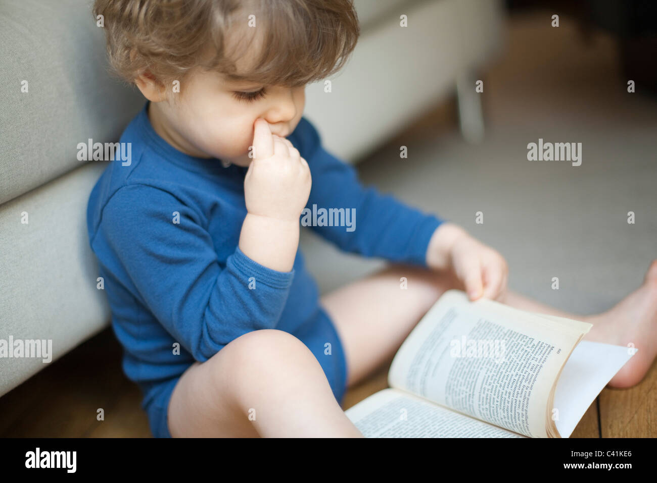 Toddler boy looking at book Stock Photo - Alamy
