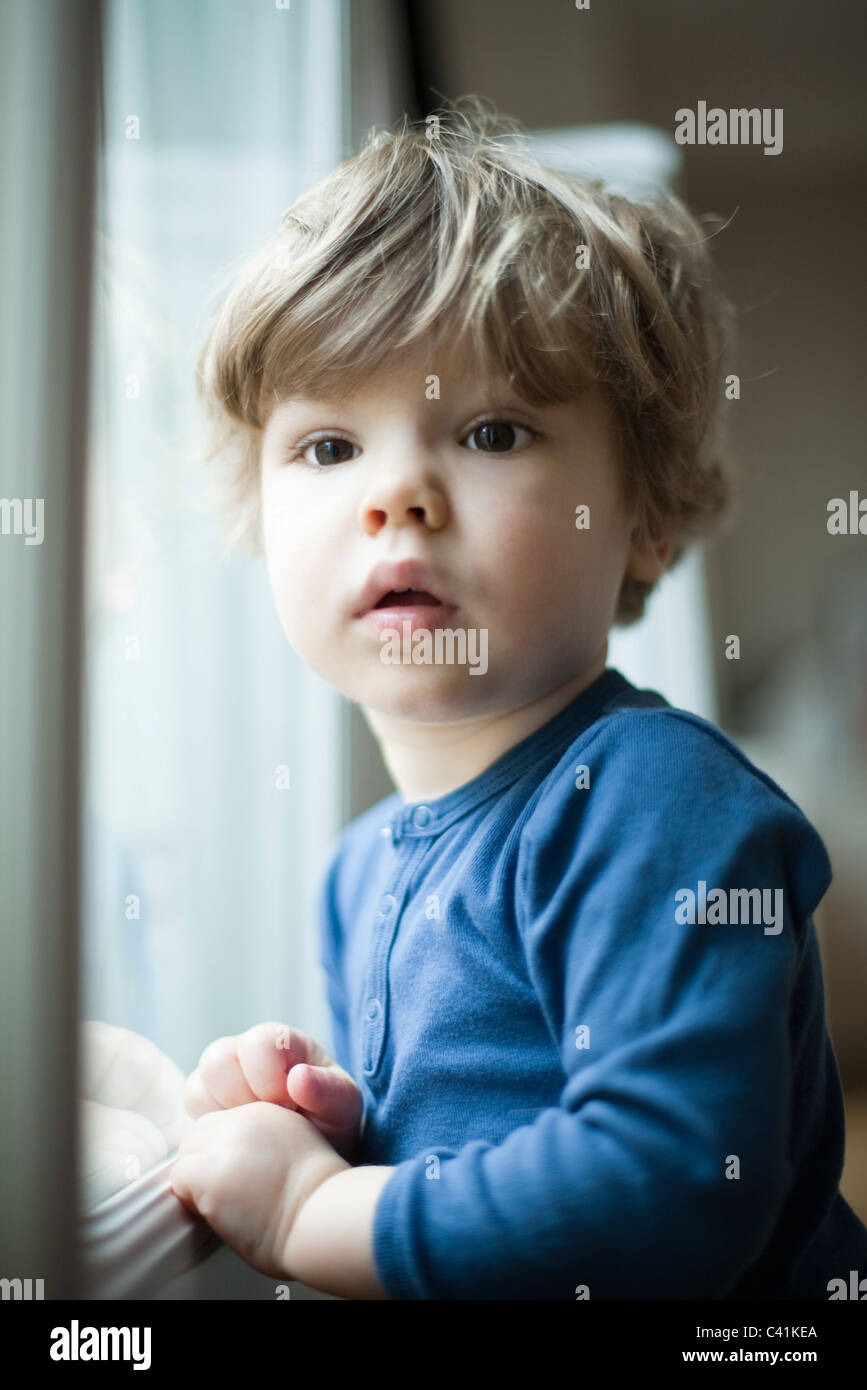 Toddler boy by window, portrait Stock Photo - Alamy