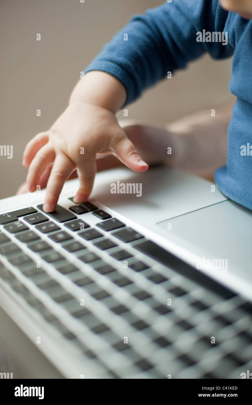 Child's hand touching laptop keyboard Stock Photo - Alamy