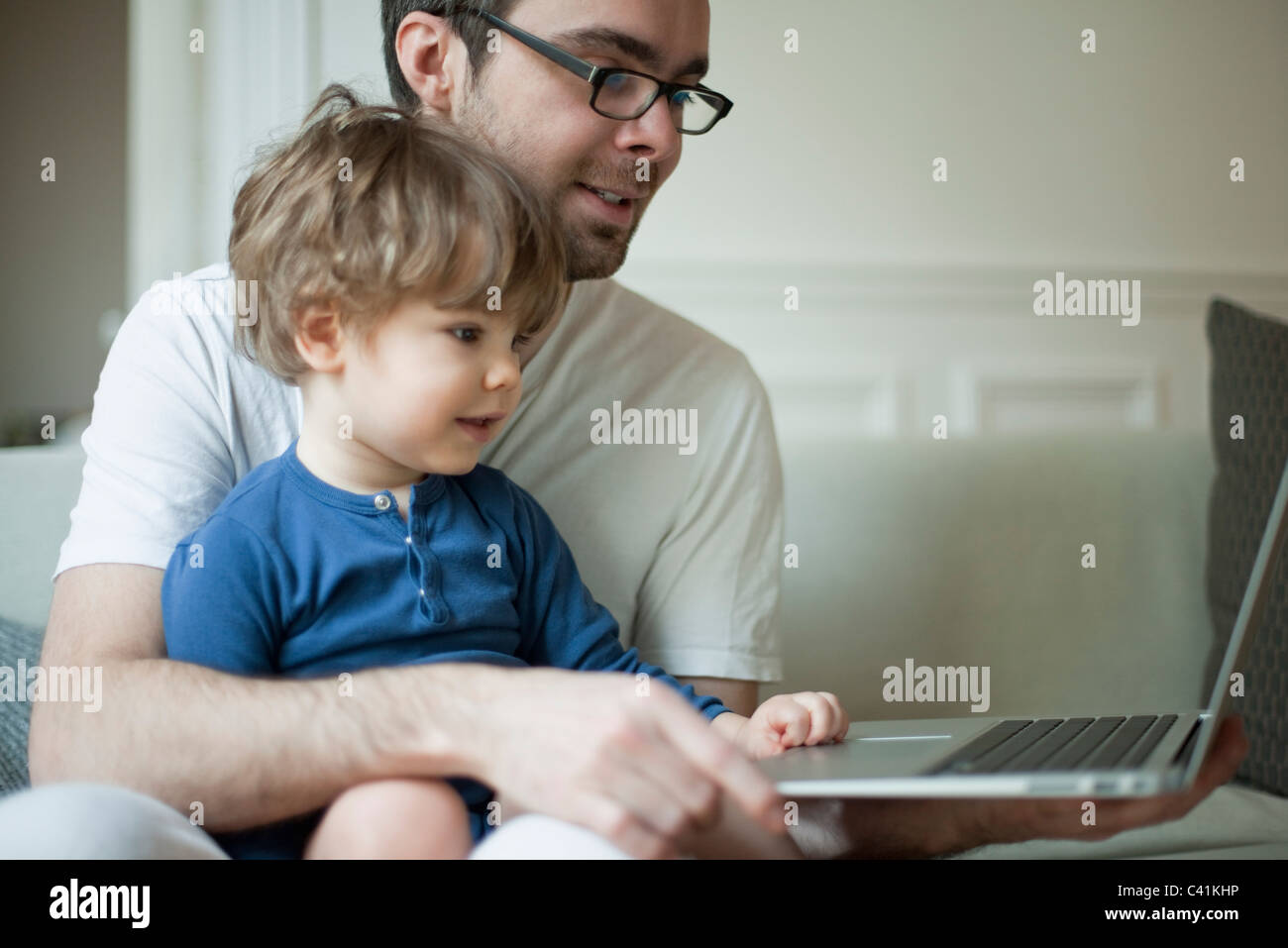 Toddler boy using laptop computer with father Stock Photo - Alamy
