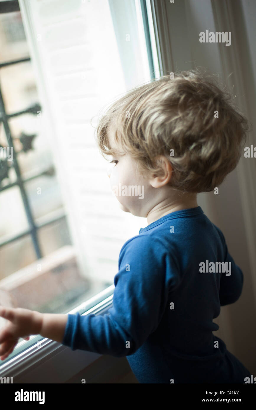 Toddler boy looking out window Stock Photo - Alamy