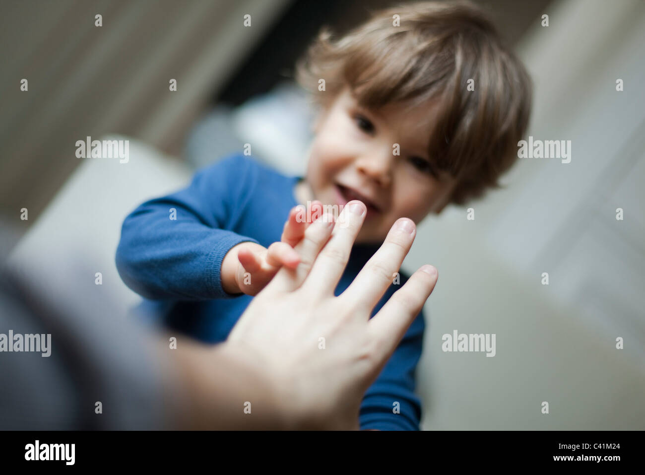 Toddler boy touching parent's hand Stock Photo - Alamy