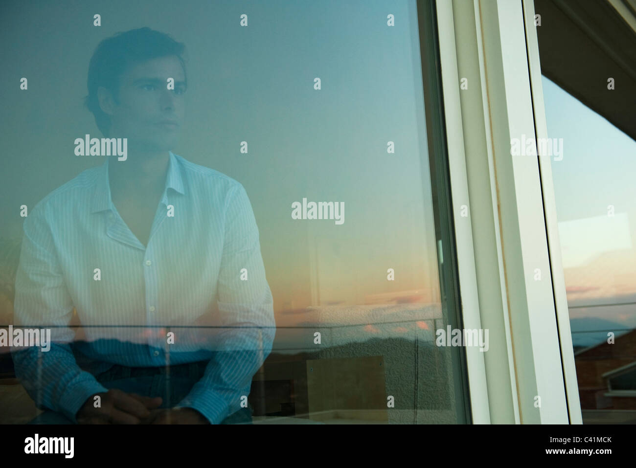 Man looking through window Stock Photo - Alamy