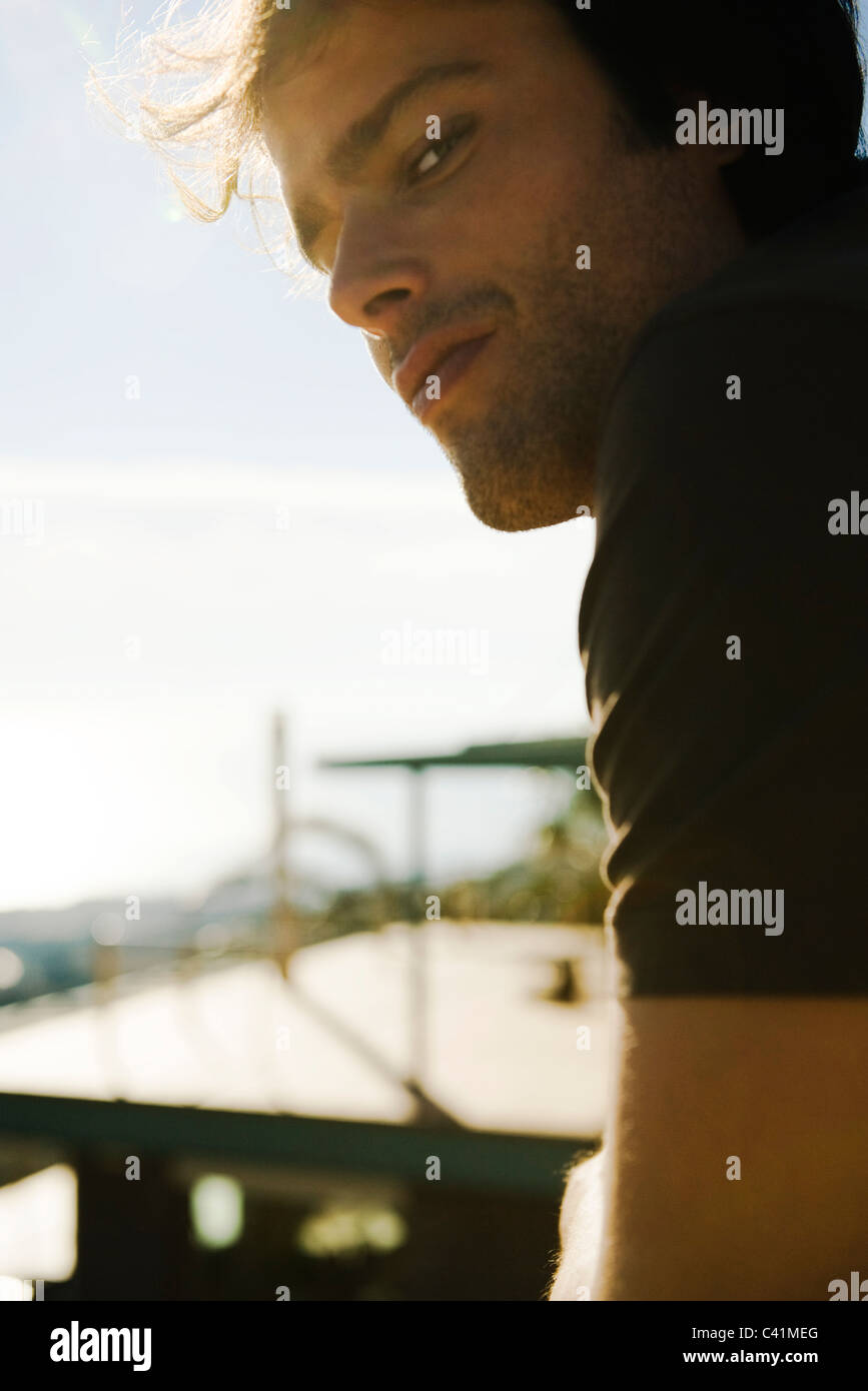 Man looking over shoulder at camera, portrait Stock Photo - Alamy
