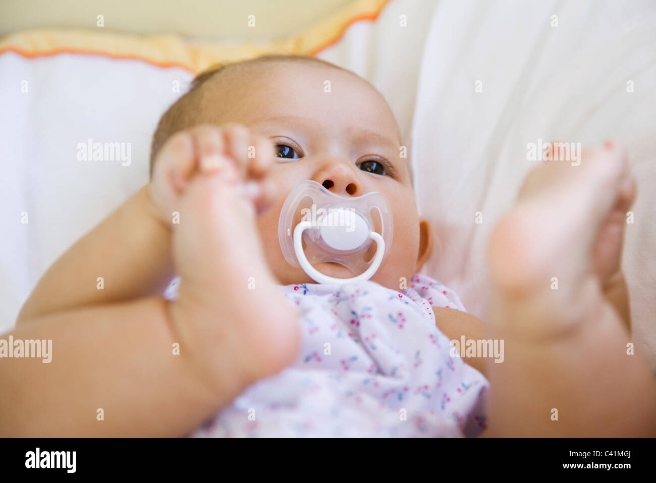 Baby touching feet, portrait Stock Photo - Alamy