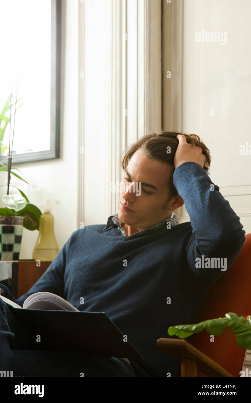 Man reading book with confusing look Stock Photo - Alamy