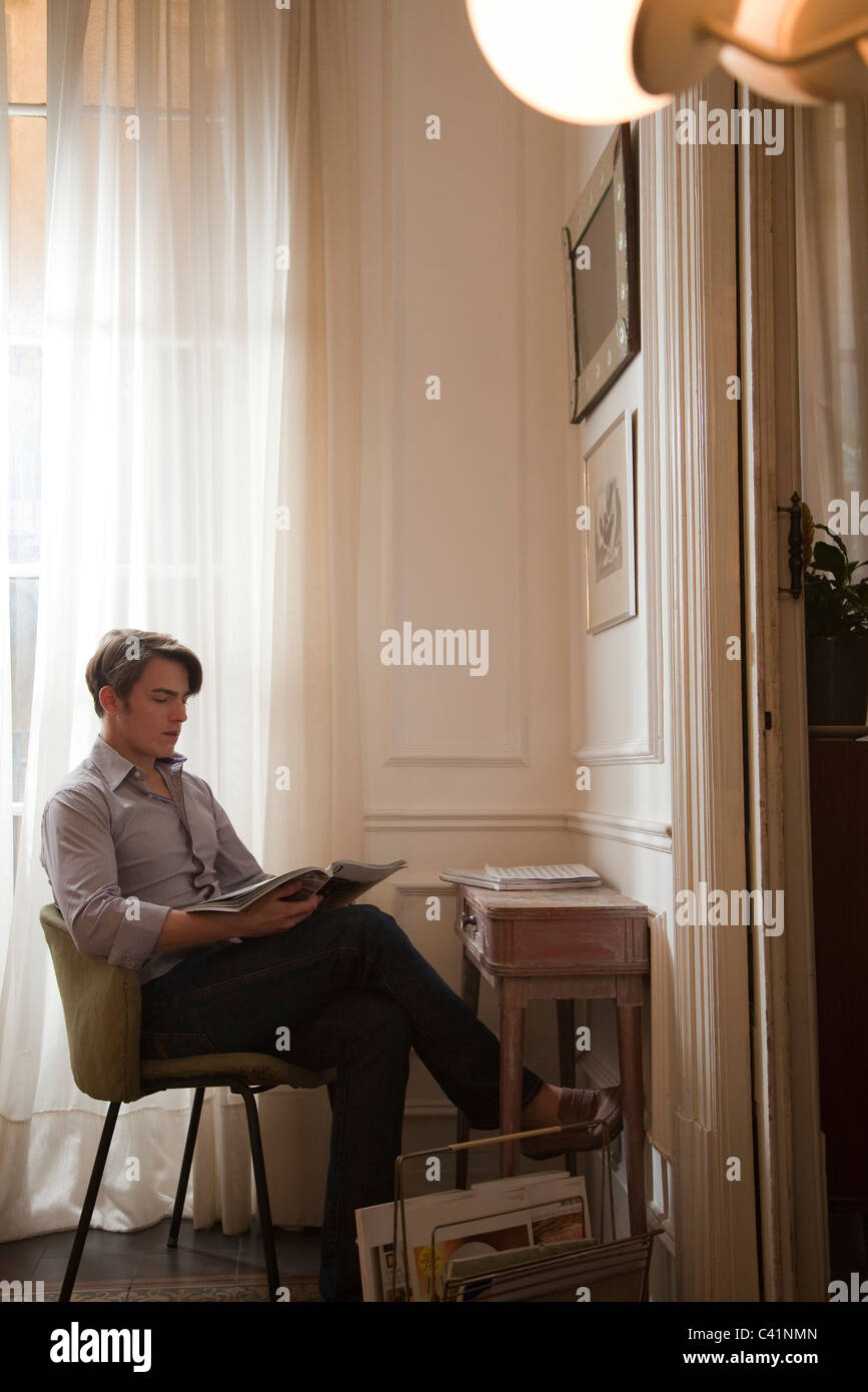 Young man reading magazine Stock Photo - Alamy