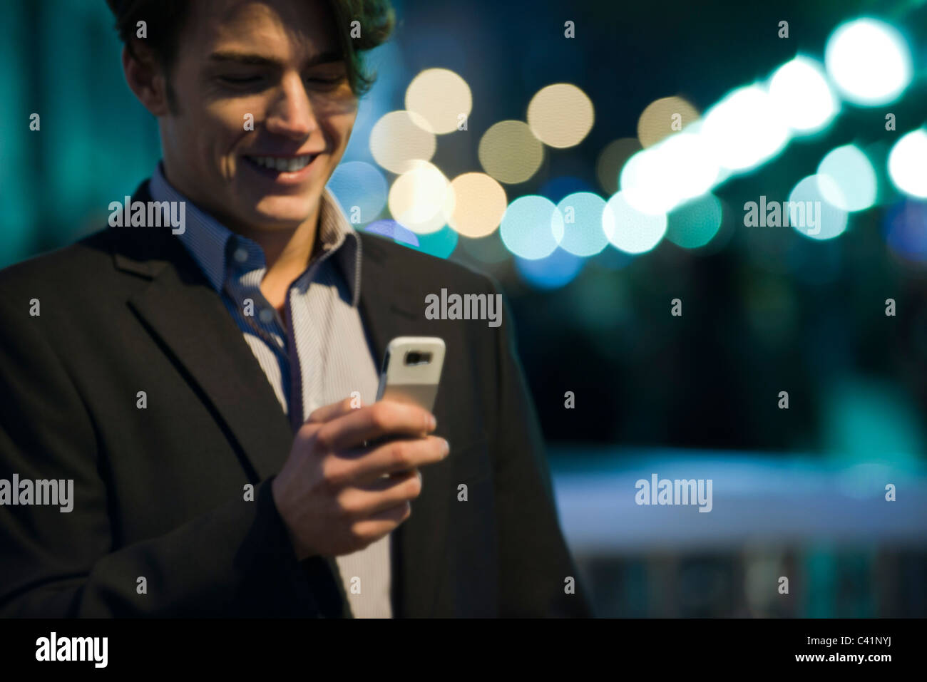 Man text messaging outdoors at night Stock Photo - Alamy