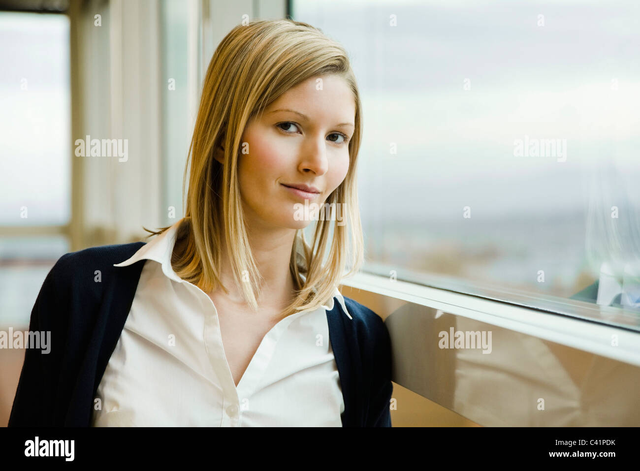 Woman leaning against window, portrait Stock Photo - Alamy