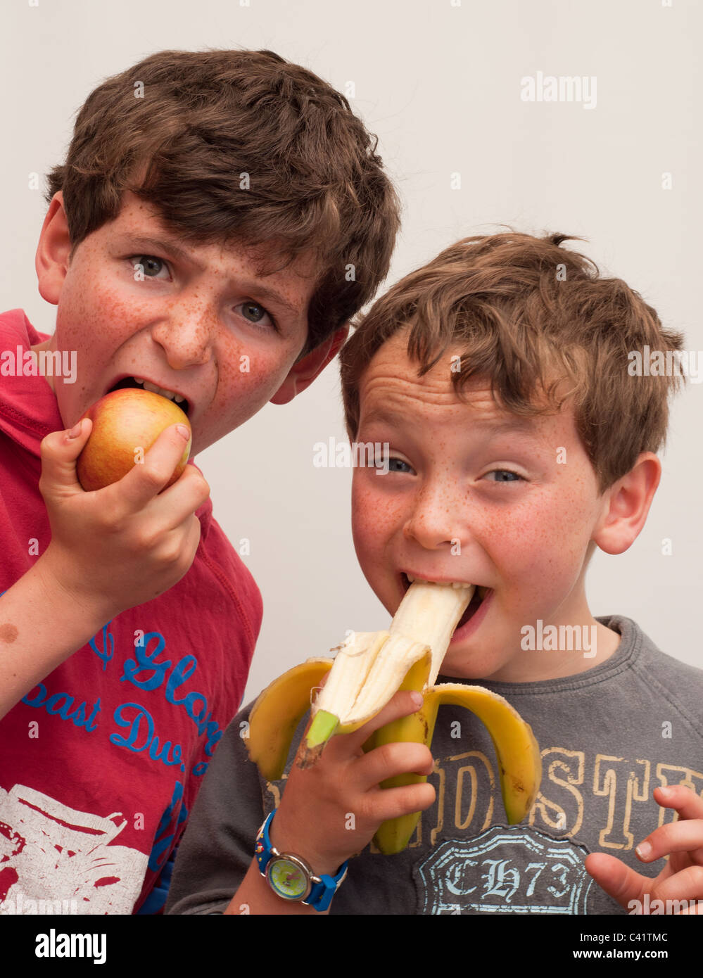 Two boys eating fruit Stock Photo - Alamy