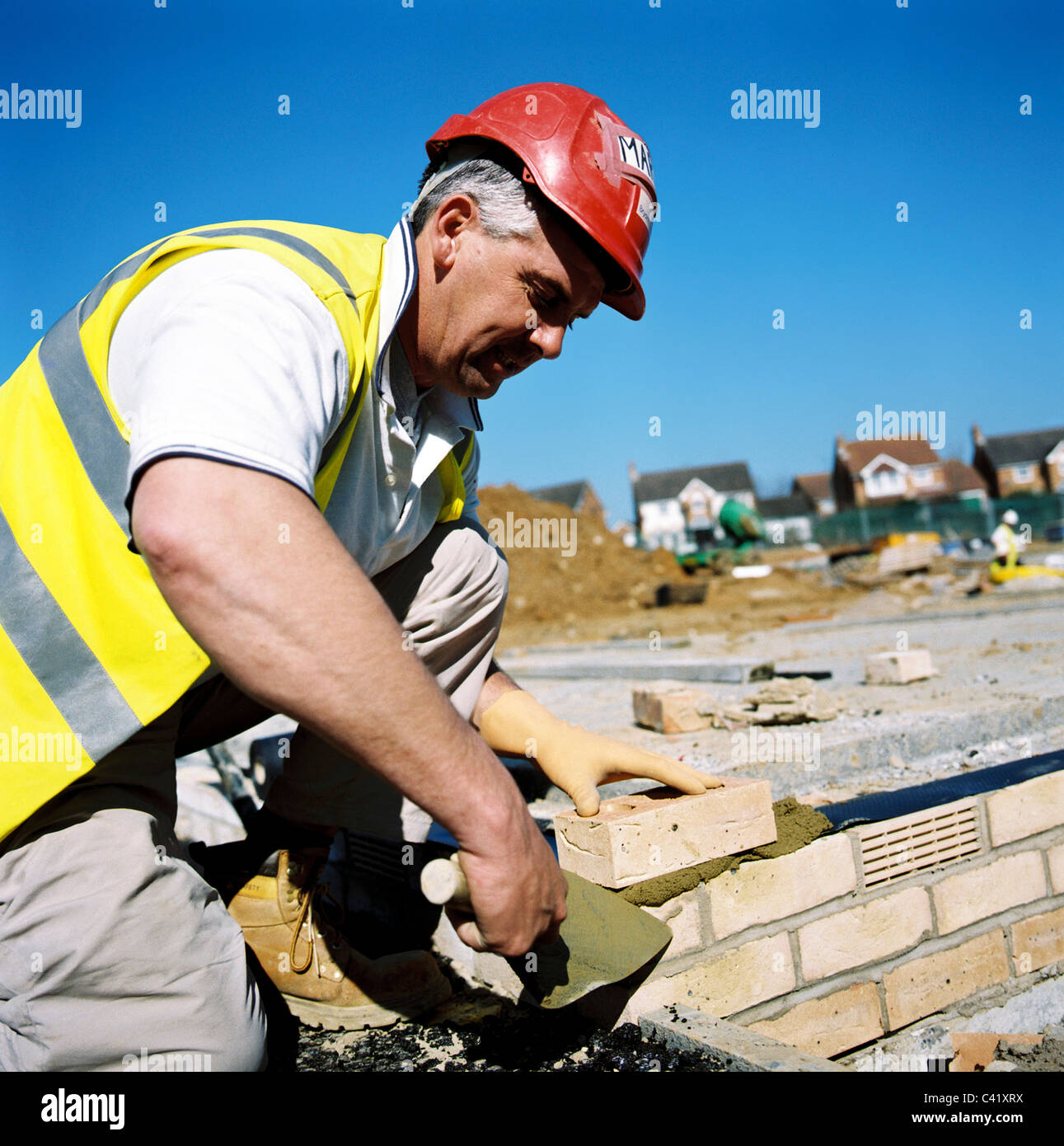 Bricklayer applying cement onto bricks Stock Photo - Alamy