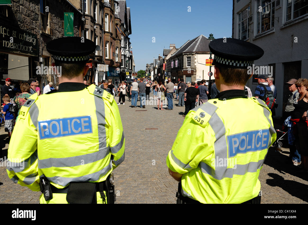 Policemen control crowd in town high street with high visibility vests ...