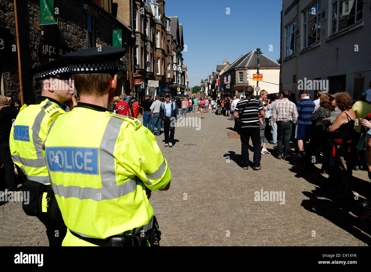 Policemen control crowd in town high street with high visibility vests ...